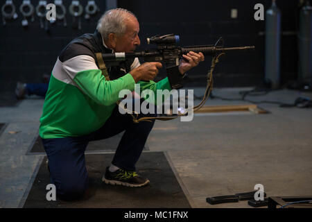Bill Glynn from Boise, Idaho, shoots a mock M16-A4 rifle at the indoor ...