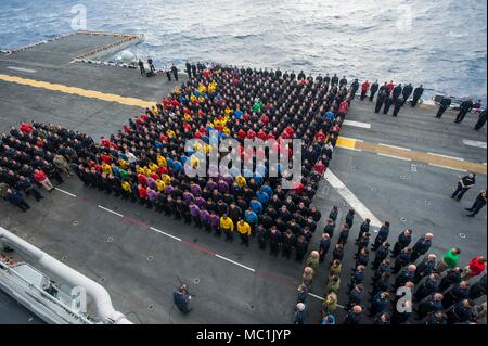 The crew stands in formation on the deck of the nuclear-powered attack ...