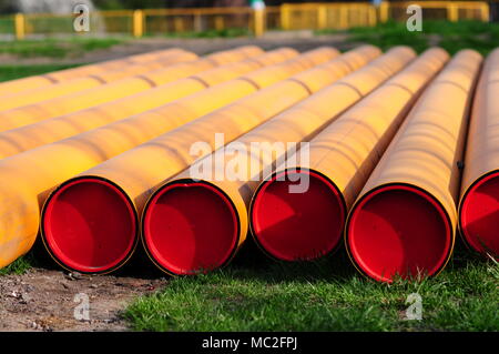 PVC pipes lying in a row on the grass Stock Photo - Alamy