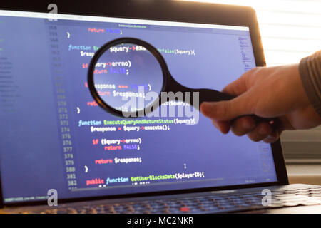 PHP back-end code zoomed through a magnifier. Computer programming source code lookup. Abstract ...