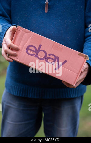 Man holding a box of goods selling online Stock Photo - Alamy