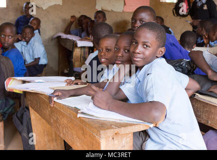 Uganda. June 13 2017. Smiling Ugandan children sitting at desks in a ...