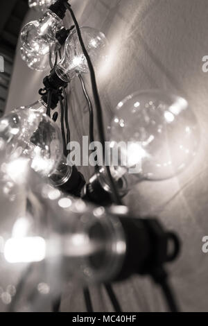 Bottom view of light bulbs background over dark wall Stock Photo - Alamy