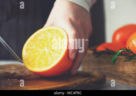 Hands of woman slicing ripe orange on cutting board Stock Photo - Alamy