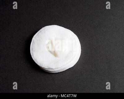 Cotton disc with cream on black background Stock Photo - Alamy