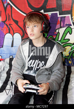 Boy playing on Xbox one in his bedroom Stock Photo - Alamy