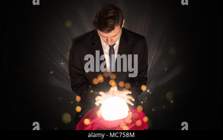 Gorgeous businessman sitting with sparkling magic ball in his lap Stock ...