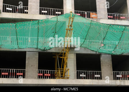 Building under construction with safety netting against falling debris ...