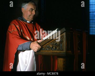 CHRISTIAN Anglican priest reading from the Holy Bible at a lectern ...
