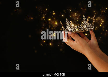 Woman's hand holding a crown for show victory or winning first place ...