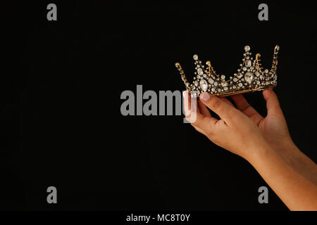 Woman's hand holding a crown for show victory or winning first place ...