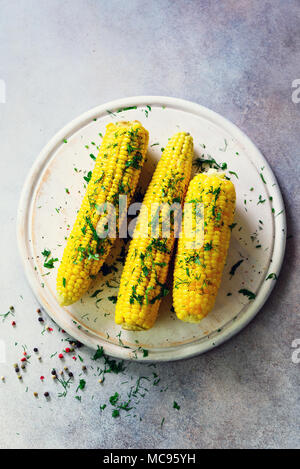 Boiled corn with spices on grey light concrete background. Copy space ...