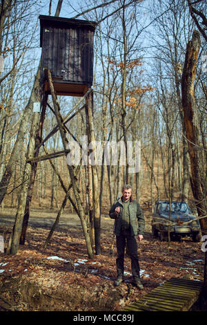Game ranger with gun at the feeding spot for wild animals Stock Photo ...