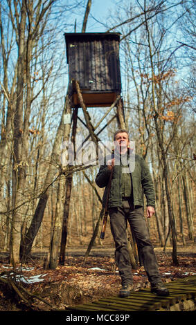 Game ranger with gun at the feeding spot for wild animals Stock Photo ...
