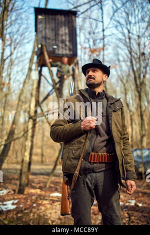 Game ranger with gun at the feeding spot for wild animals Stock Photo ...