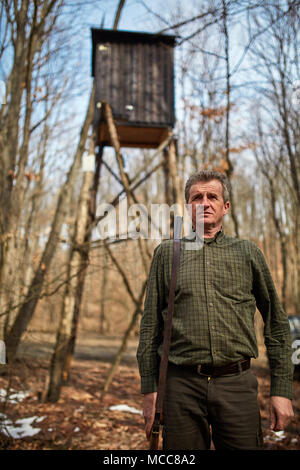 Game ranger with gun at the feeding spot for wild animals Stock Photo ...