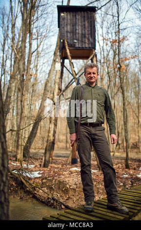 Game ranger with gun at the feeding spot for wild animals Stock Photo ...