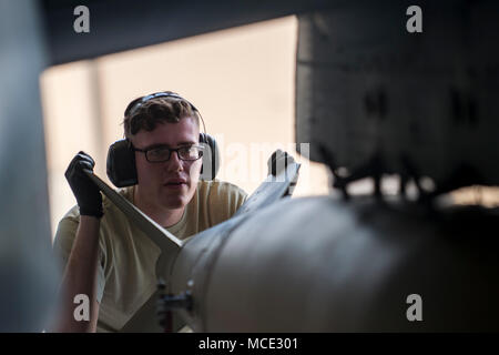 Airman 1st Class Joseph Capshaw, helps in attaching an inert MK-84 ...