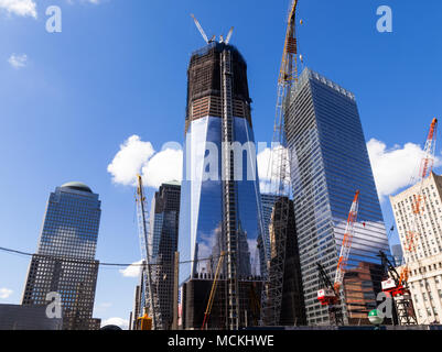 A low angle shot of cranes and construction sites against a cloudy sky ...