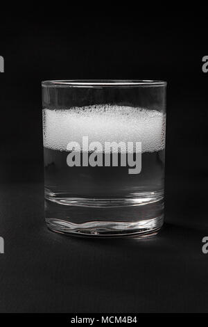 Monochrome transparent cocktail, soda, foam, boom, in a low glass. Side ...