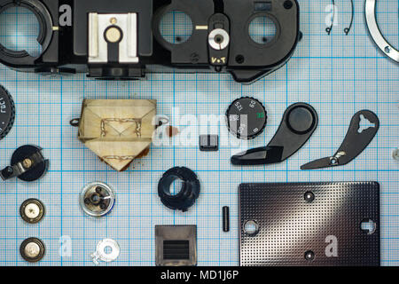parts are completely disassembled old retro film SLR camera on graph ...