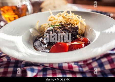 Confit beef steak with sauce fried onion bread draft beer and ...