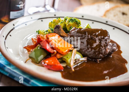 Confit rabbit leg with vegetable bread redvine in pub or restaurant ...