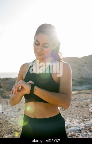 Young female runner checking smartwatch Stock Photo - Alamy