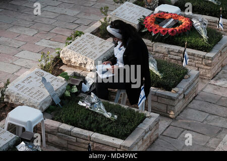 A Jewish woman praying at the grave of an Israeli fallen soldier on Yom ...