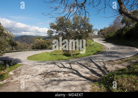 Hairpin bend, winding road through spanish countryside, with white car ...