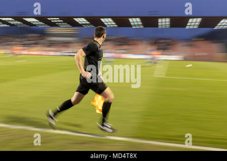 Soccer / football referee assistant, linesman points flag to indicate ...