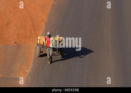 Man pulling a handcart which is know as a 'mkokoteni' Swahili, loaded ...