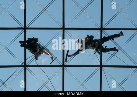 19 April 2018, Germany, Dresden: A building cleaner cleaning the glass ...