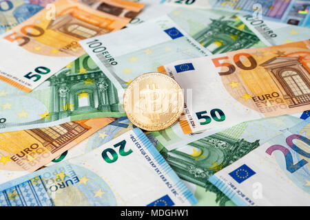Gold Bitcoin coin on bills of euro banknotes. Worldwide virtual ...
