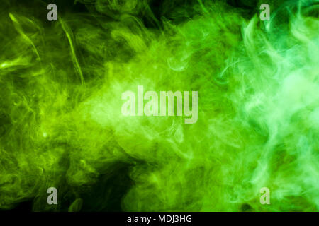 Dense multicolored green smoke on a black isolated background ...