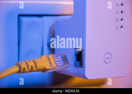 Insert ethernet cable into WiFi extender device which is in electrical ...