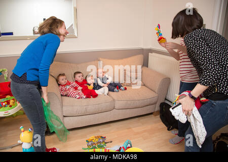Parents trying to entertain babies Stock Photo - Alamy