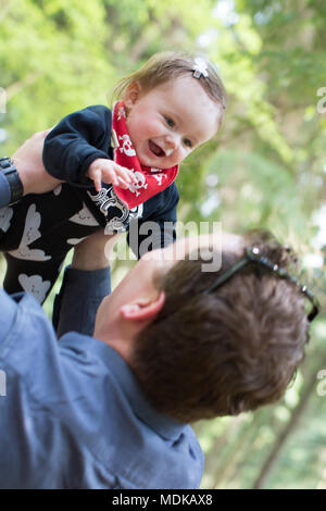 Dad Lifting Infant Daughter as Baby Laughs & Mom Watches Stock Photo ...