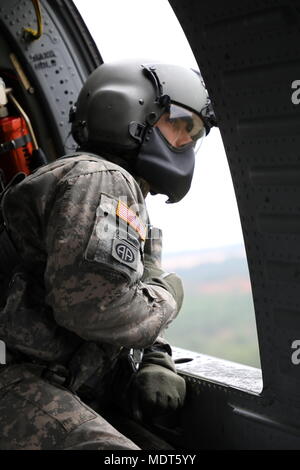 The door gunner of a UH-60 Blackhawk helicopter fires his M240H at ...