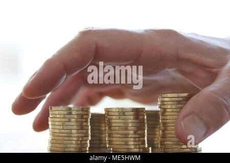 Love of money - Greedy hand grabbing or reaching out for pile of golden ...