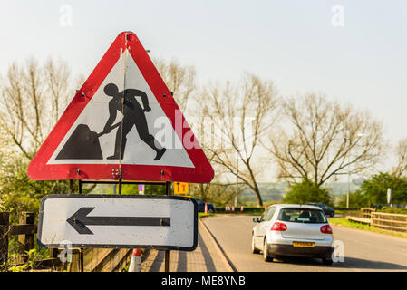 roadworks directional arrow sign on UK motorway at evening with traffic ...