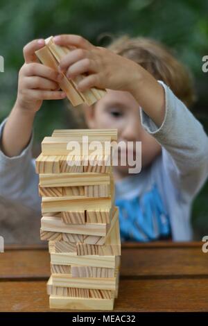 happy friends playing jenga game, focus on foreground Stock Photo - Alamy