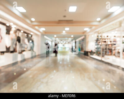Defocused shopping mall interior with bright lights and modern ...