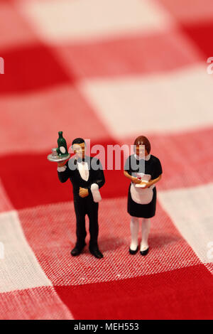 Miniature scale model waiter and waitress on a till receipt bill with ...