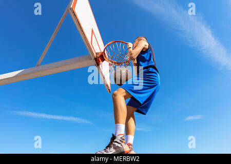 Slam Dunk. Side view of young basketball player making slam dunk Stock ...