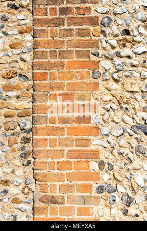 A close up showing the detail of a flint and brick wall on a building ...