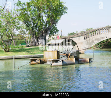 Turbine Rotating Water, Bridge and Tree in park Stock Photo - Alamy