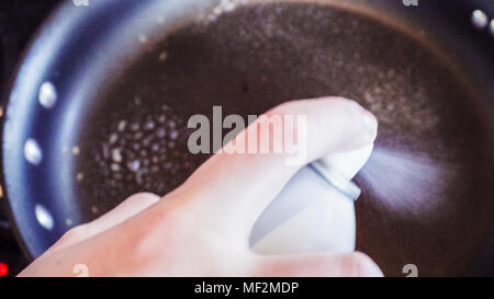 Step by step. Spraying cooking olive oil on frying pan to fry some ...