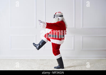 Santa Claus experiencing virtual reality at home and playing videogames ...