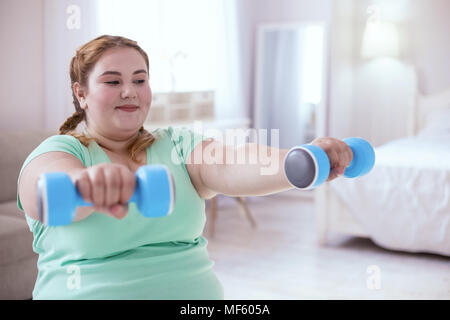 Beautiful young woman repeating exercises while watching online ...